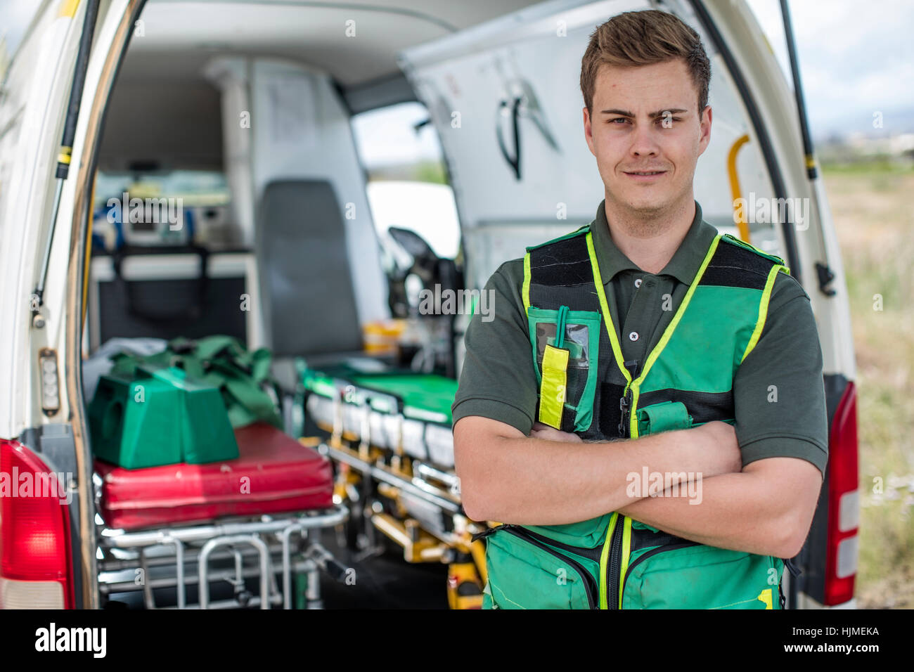 Paramedic standing with arms crossed in front of ambulance Stock Photo ...