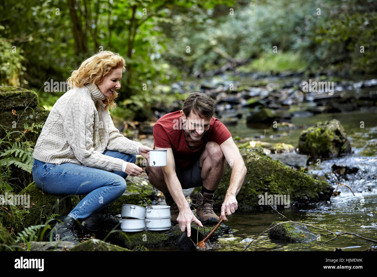 Couple washing dishes at a river Stock Photo - Alamy