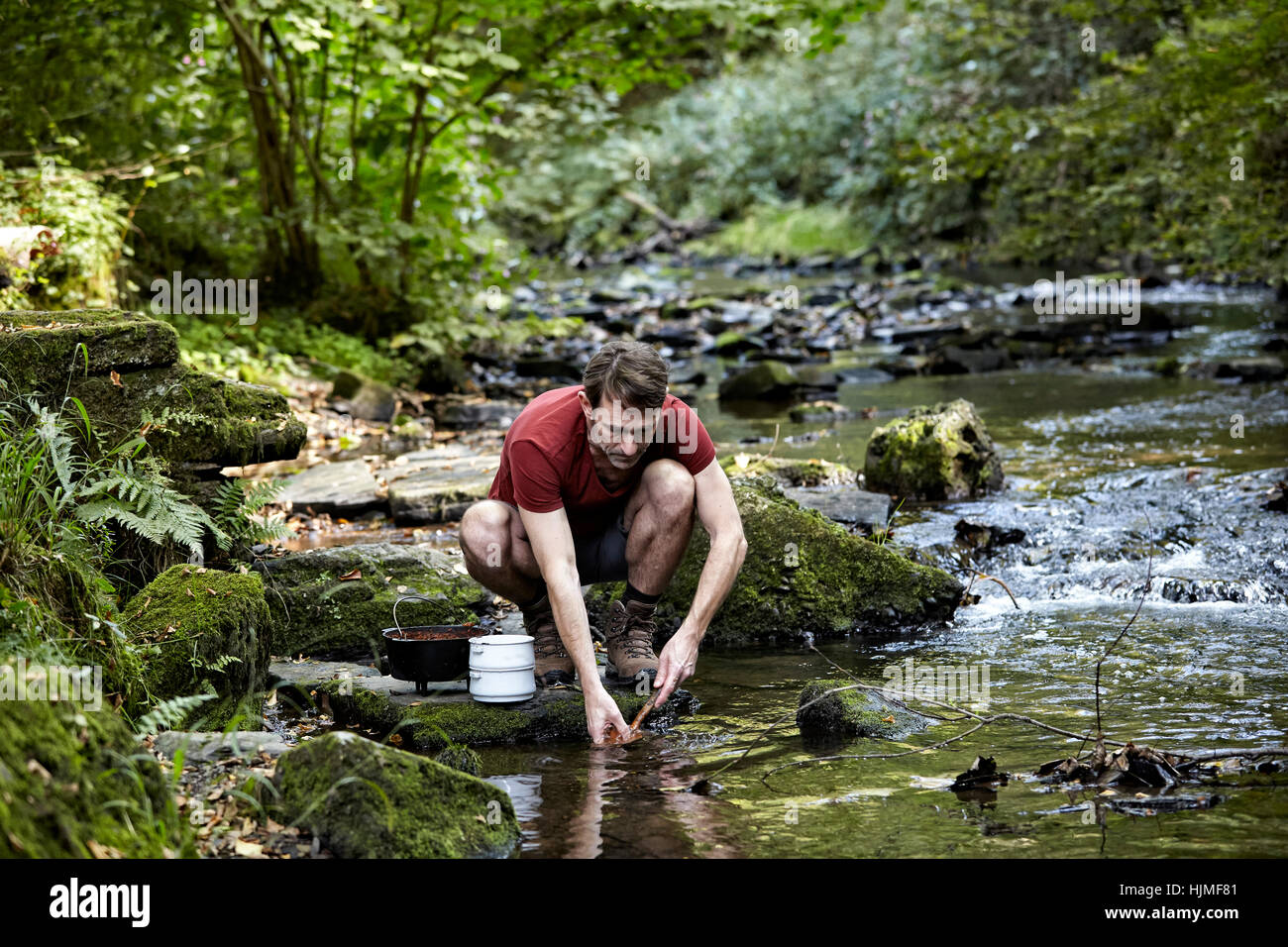 Man washing dishes at a river Stock Photo - Alamy