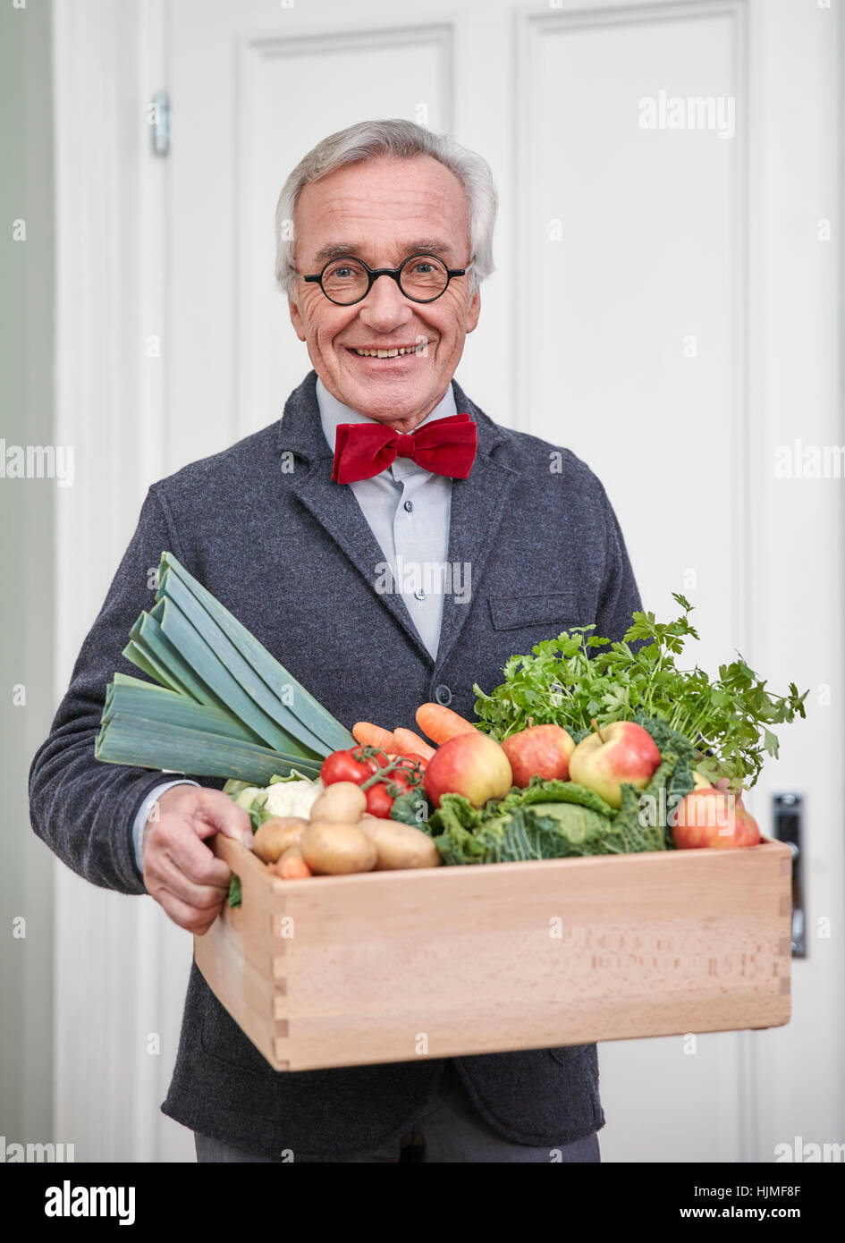 Portrait of smiling senior man holding box with produce Stock Photo - Alamy