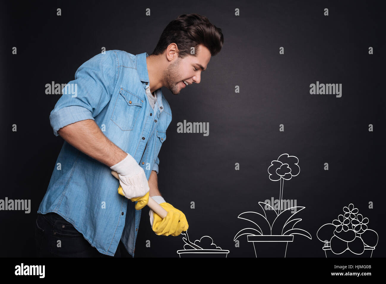 Cheerful handsome man planting flowers Stock Photo - Alamy