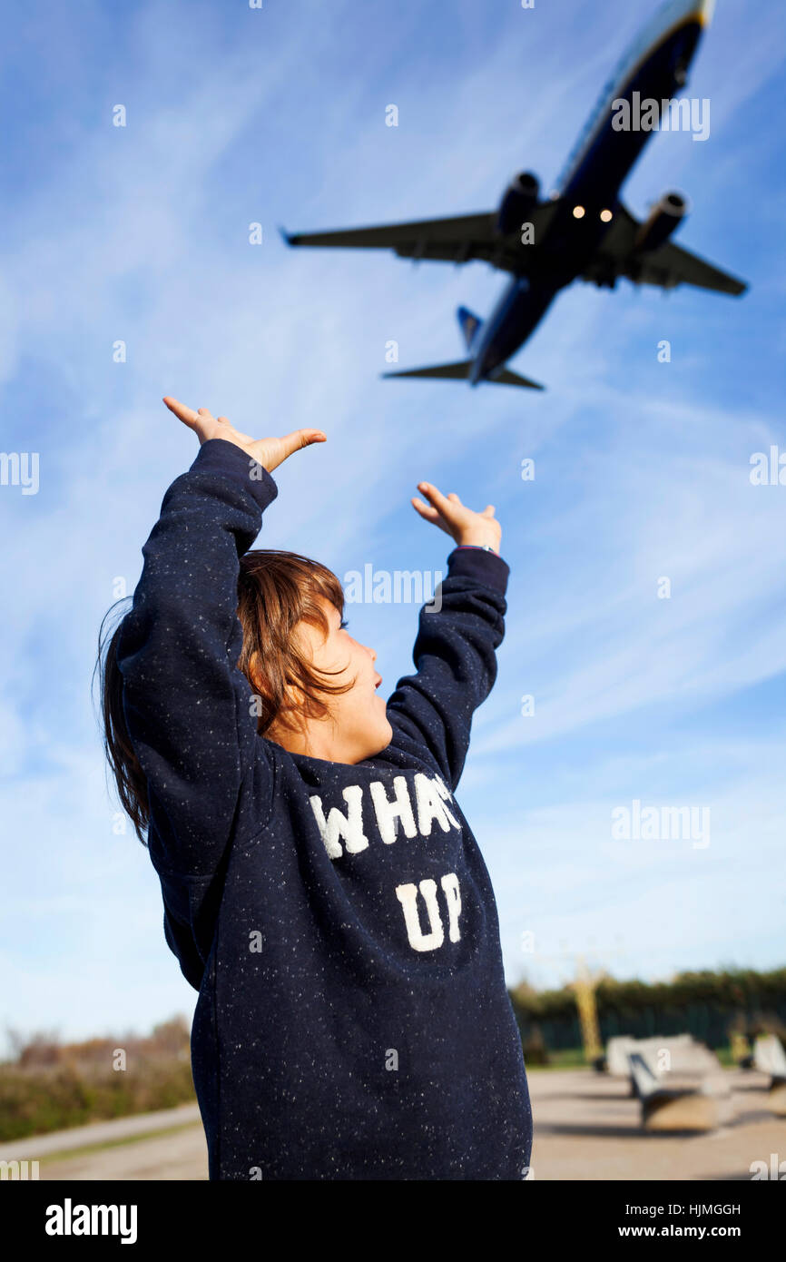 Boy reaching for landing airplane Stock Photo - Alamy