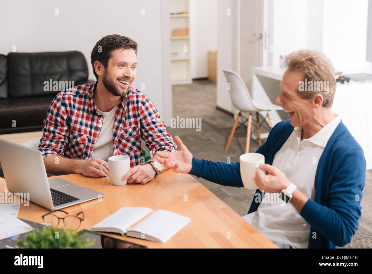 Positive nice colleagues drinking coffee Stock Photo - Alamy