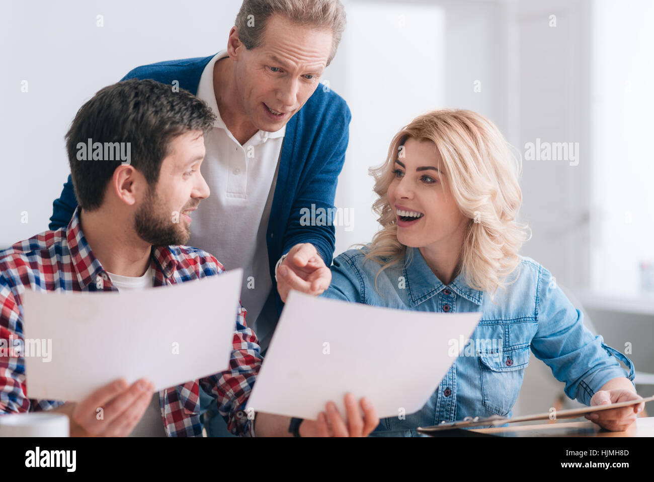 Handsome young man holding sheets of paper Stock Photo - Alamy