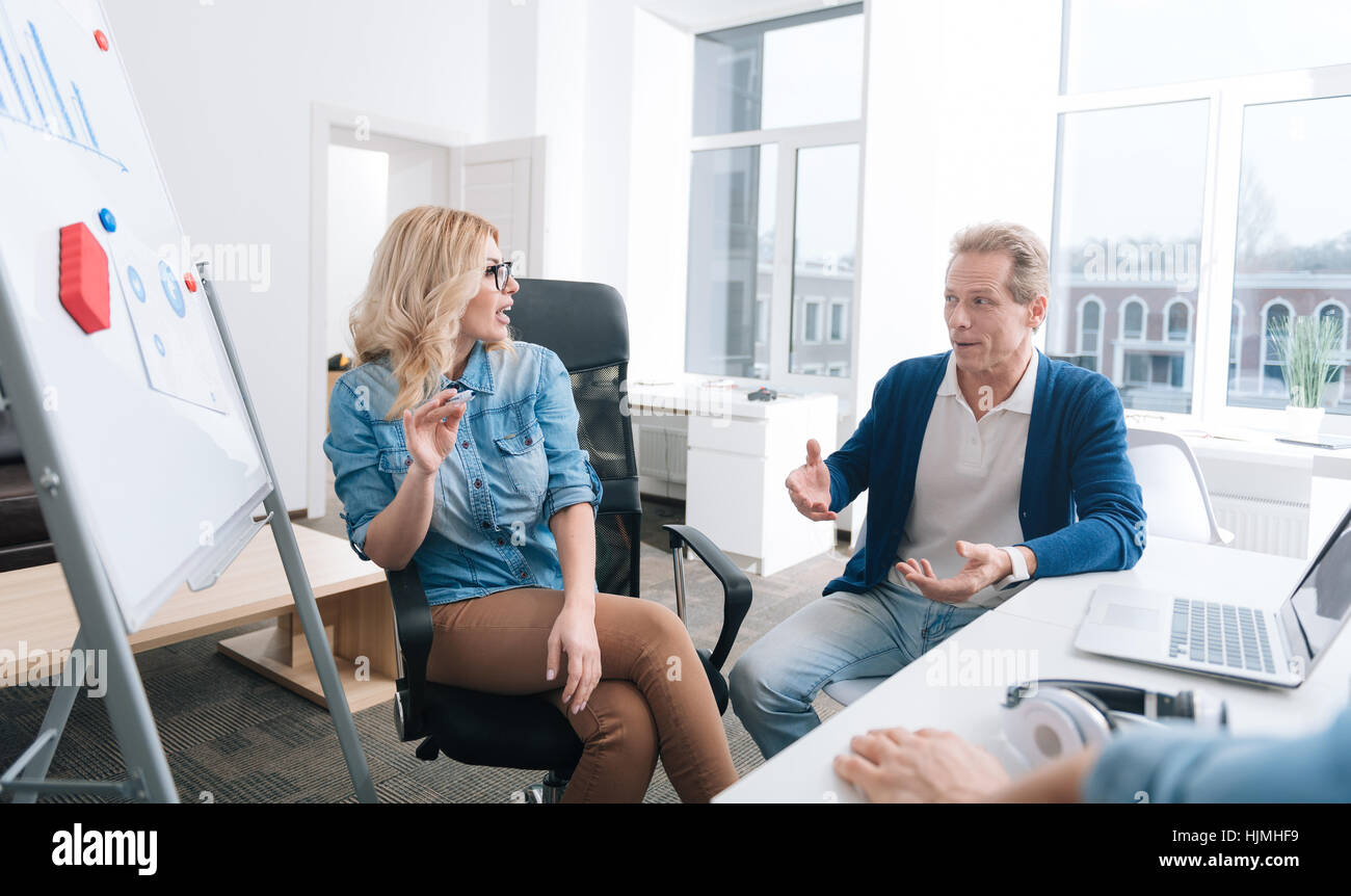 Attractive blonde woman arguing with her college Stock Photo - Alamy
