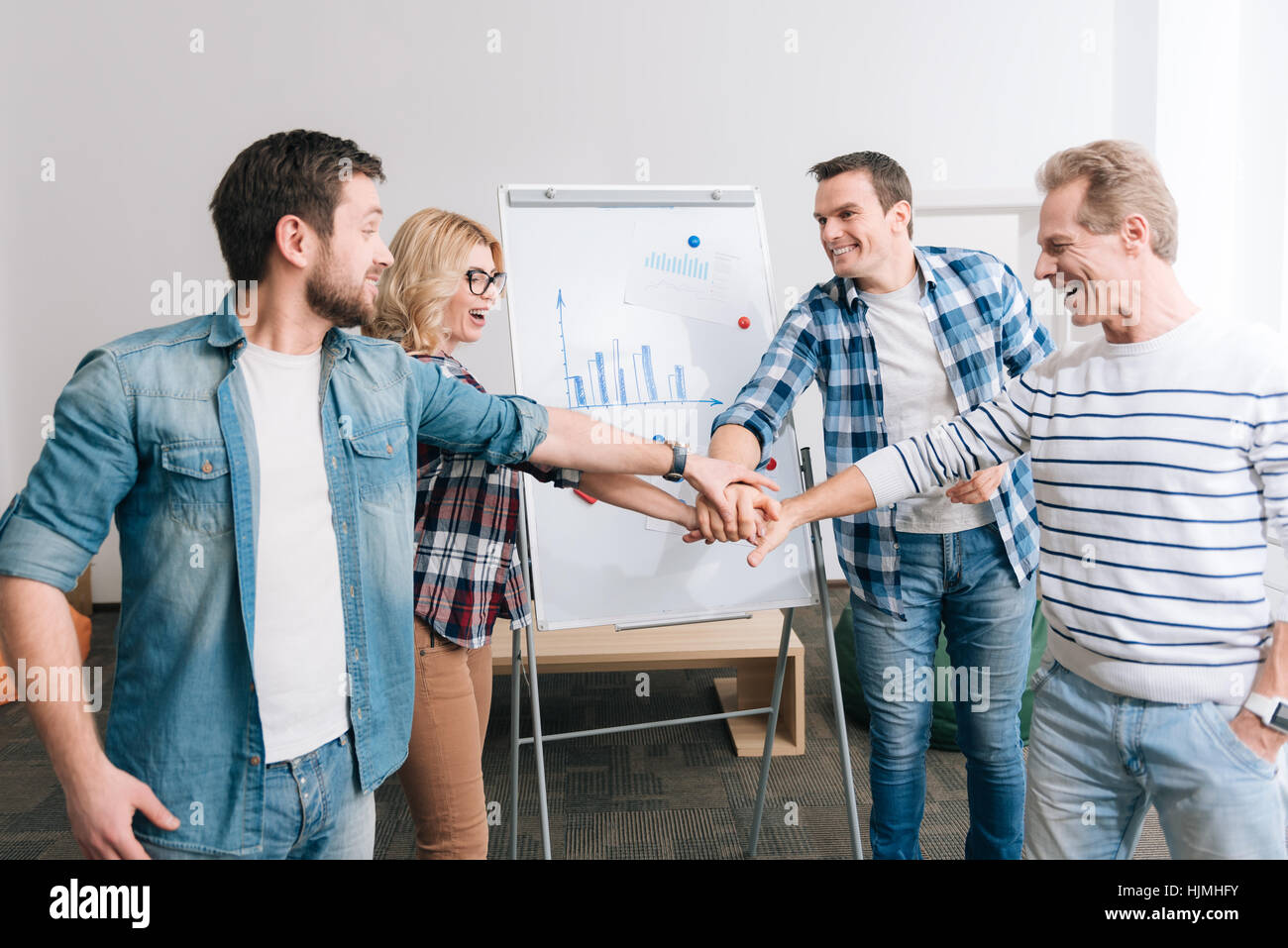 Happy cheerful people holding hands together Stock Photo - Alamy