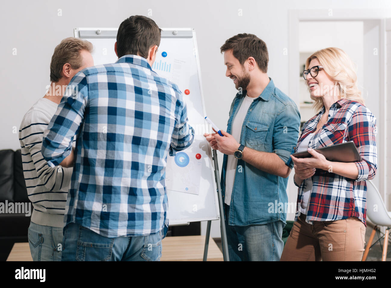 Joyful office workers standing around the whiteboard Stock Photo - Alamy