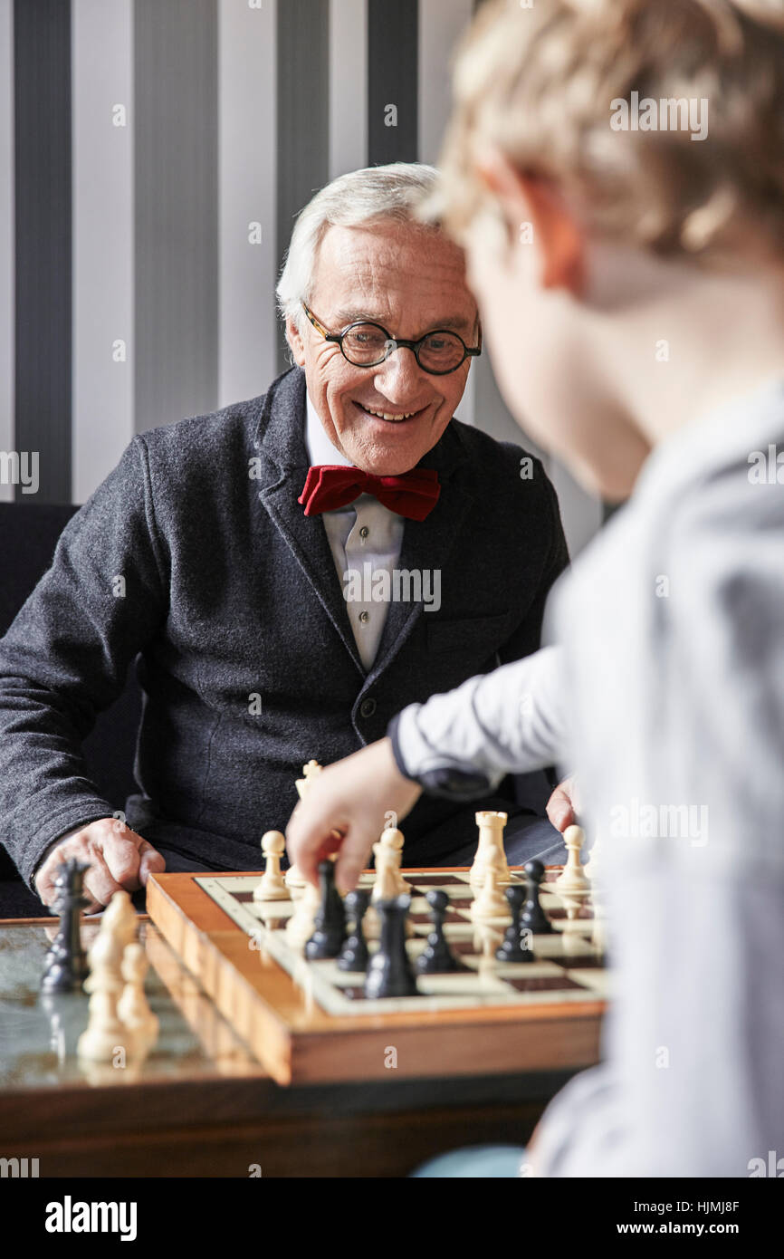 Grandfather and grandson playing chess Stock Photo - Alamy