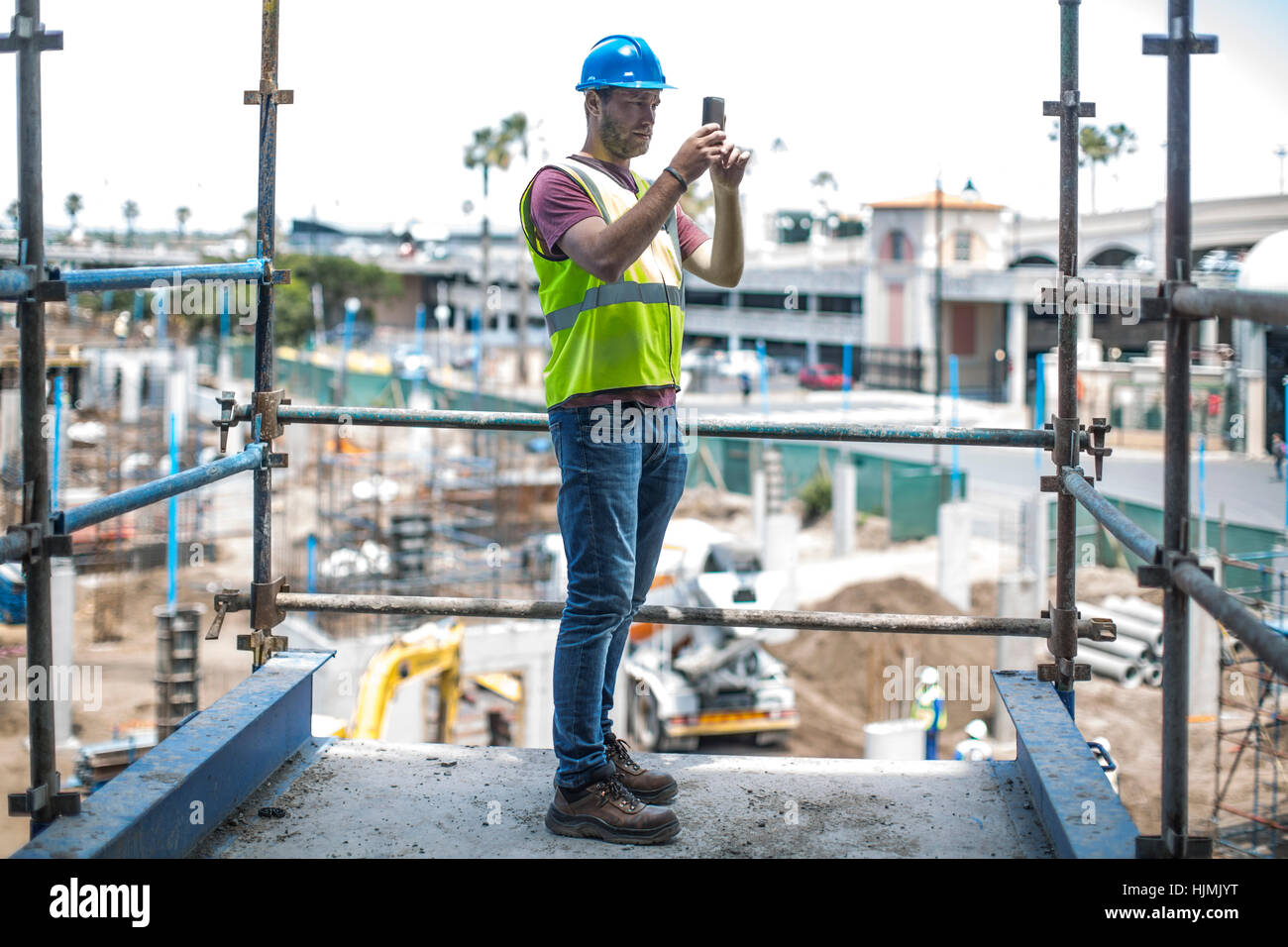 Construction worker on construction site taking pictures with smart ...