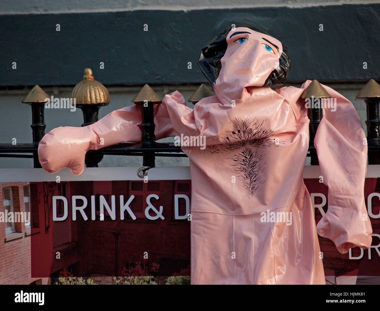 An abandoned, inflatable male figure hangs off railings in central ...