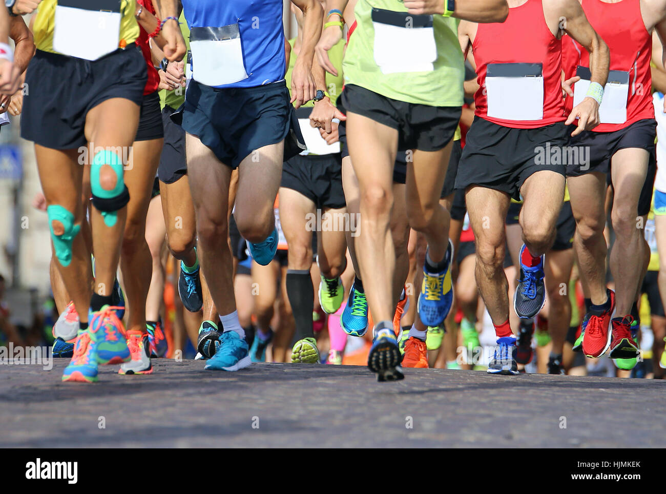 muscular legs of a large number of runners during sports race through ...