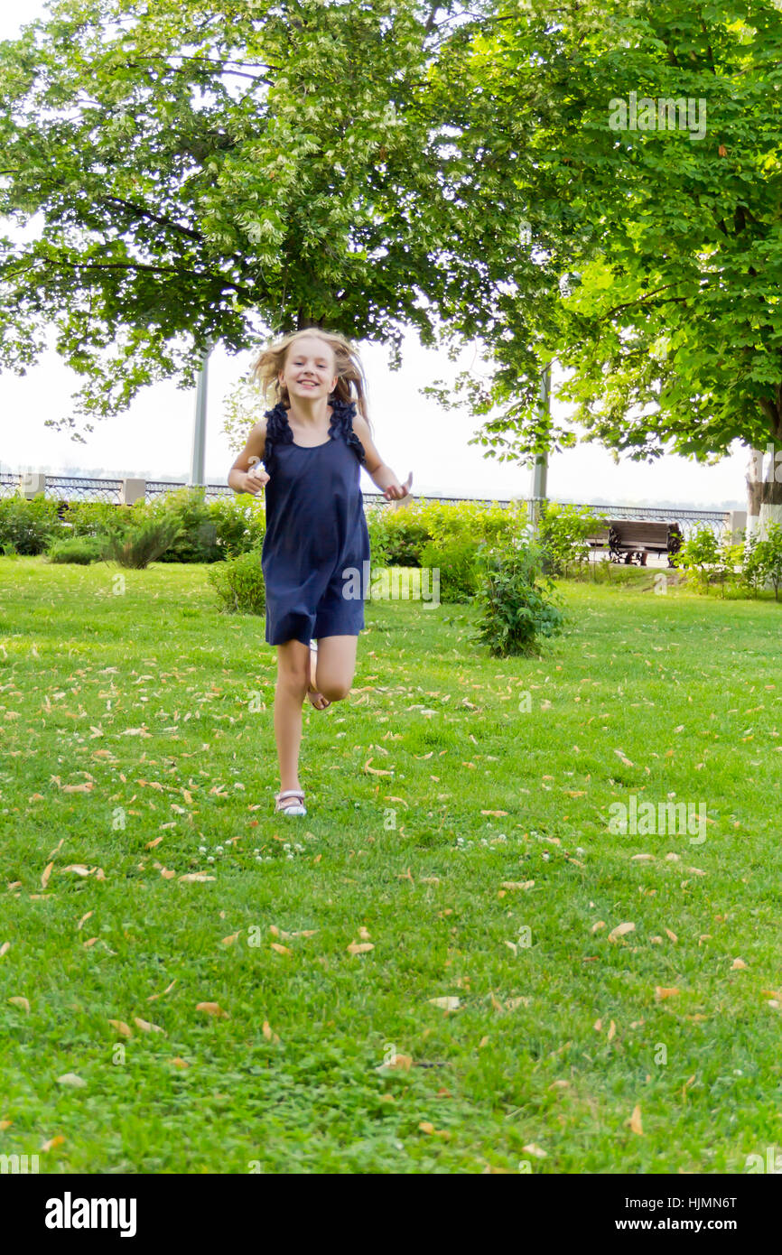 Cute running European girl in green summer Stock Photo - Alamy