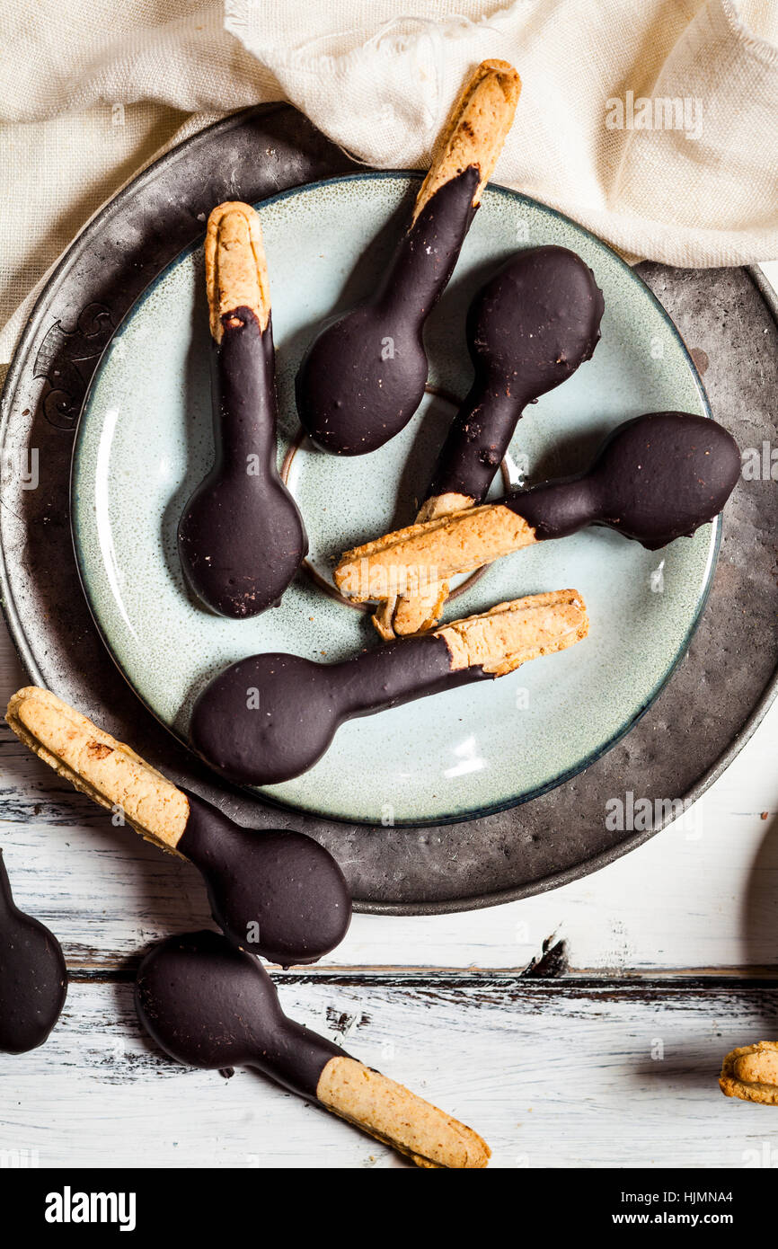 Spoon-shaped biscuits with chocolate icing on plate Stock Photo - Alamy