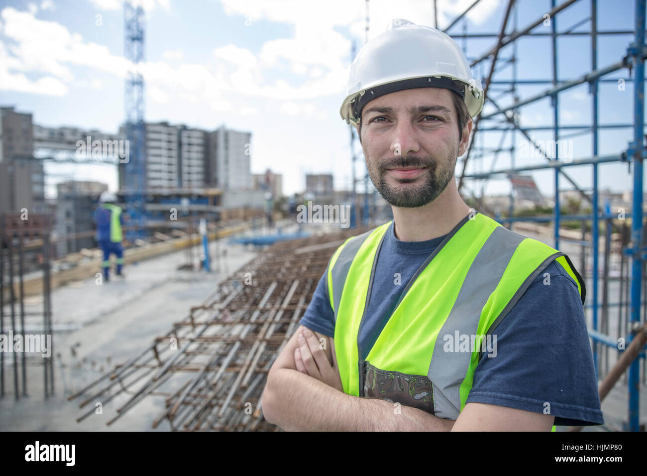 Construction worker on construction site with arms crossed Stock Photo ...
