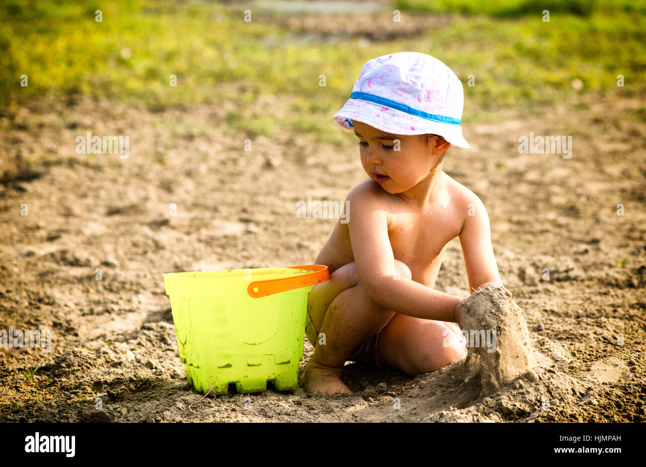 Cute little girl playing with sand Stock Photo - Alamy