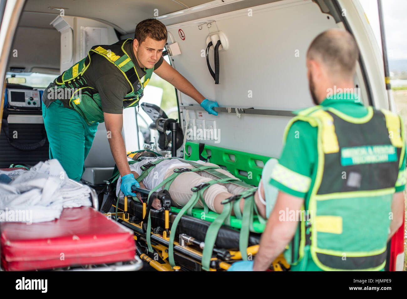Paramedics moving car crash victim on stretcher Stock Photo - Alamy