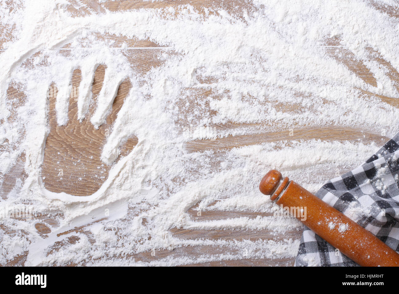 Handprint on the flour and rolling pin, a kitchen towel on the table ...