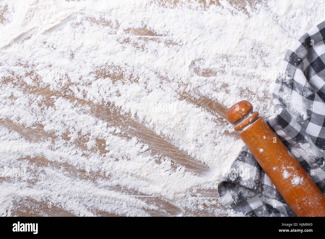 Spilling flour on the board, rolling pin and kitchen towel close up ...