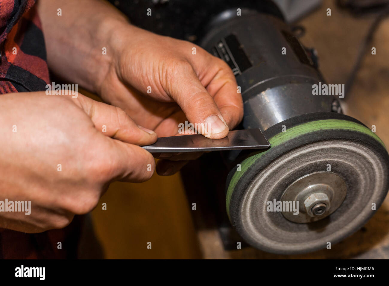 Man sharpening chisel on grinder Stock Photo - Alamy