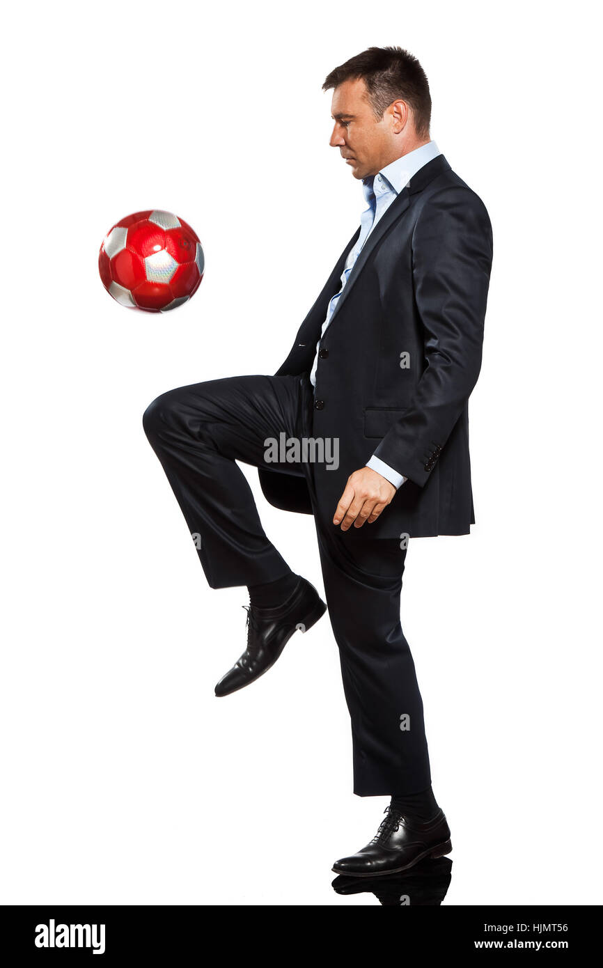 one caucasian business man playing juggling soccer ball in studio ...