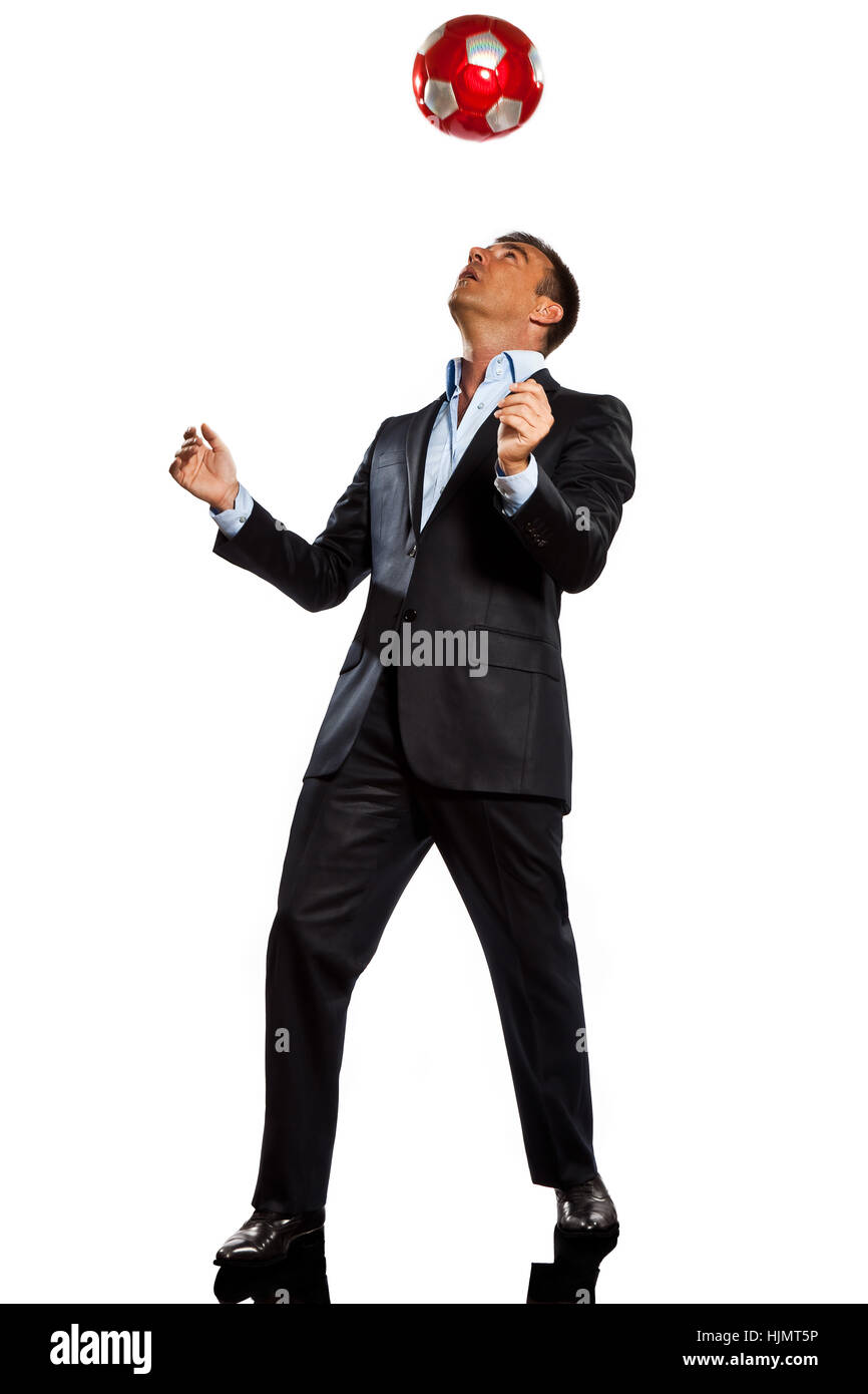 one caucasian business man playing juggling soccer ball in studio ...