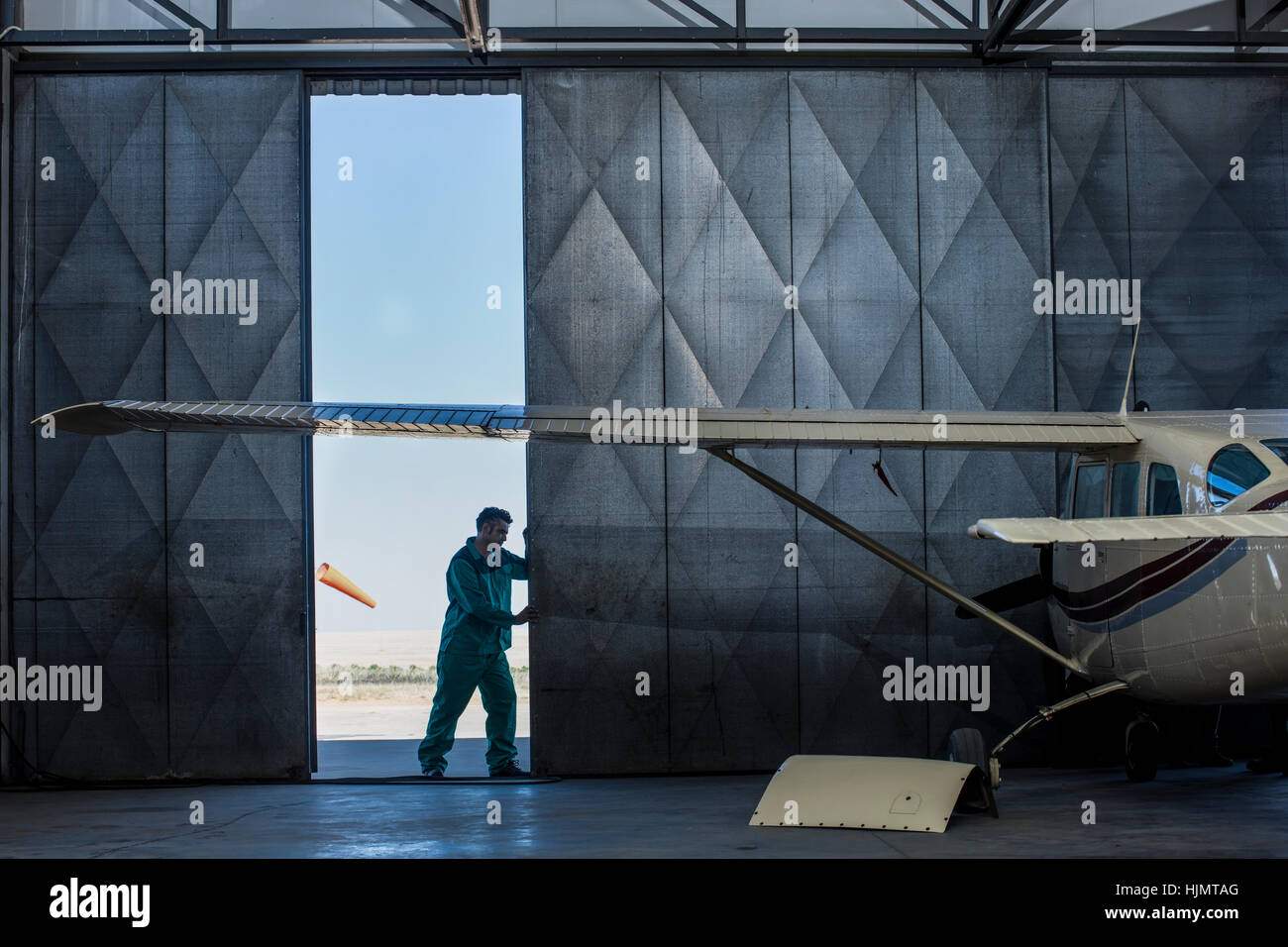 Mechanic opening hangar gate Stock Photo - Alamy
