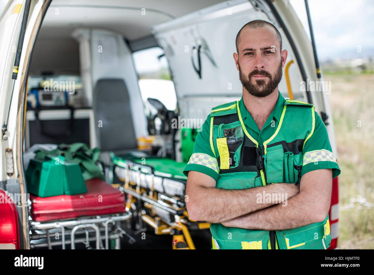 Paramedic standing with arms crossed in front of ambulance Stock Photo ...