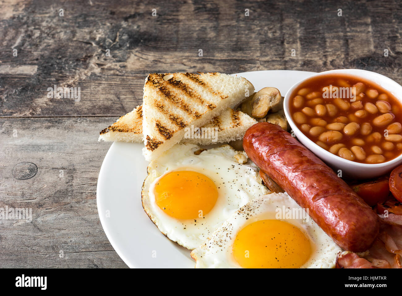 Traditional full English breakfast with fried eggs, sausages, beans ...