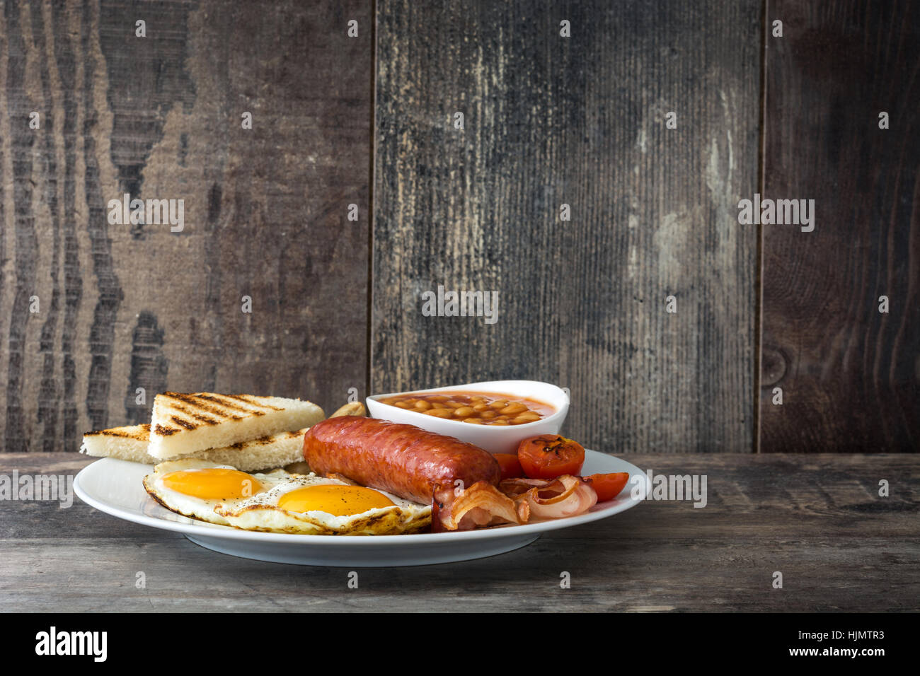 Traditional full English breakfast with fried eggs, sausages, beans ...