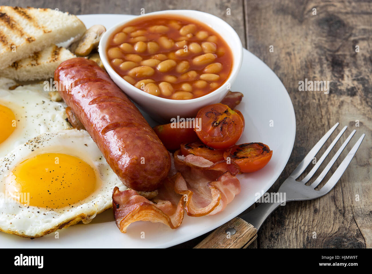 Traditional full English breakfast with fried eggs, sausages, beans ...