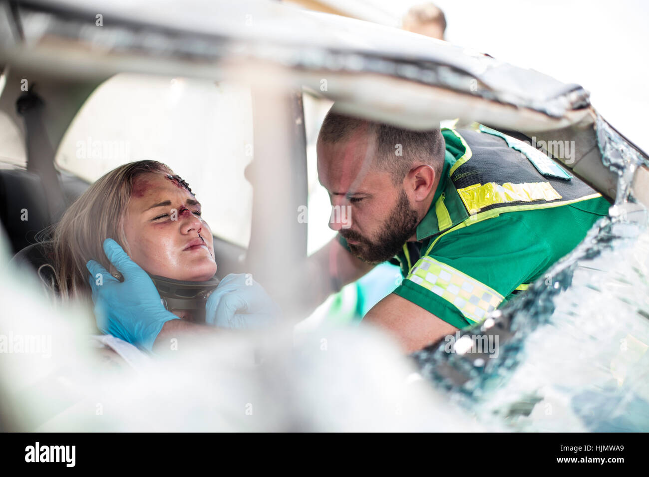 Paramedic helping car crash victim after accident Stock Photo - Alamy