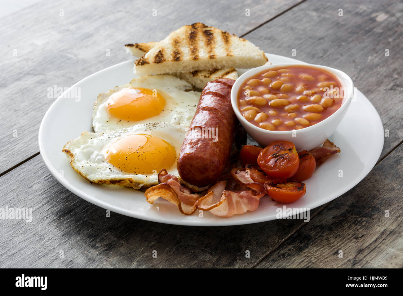 Traditional full English breakfast with fried eggs, sausages, beans ...