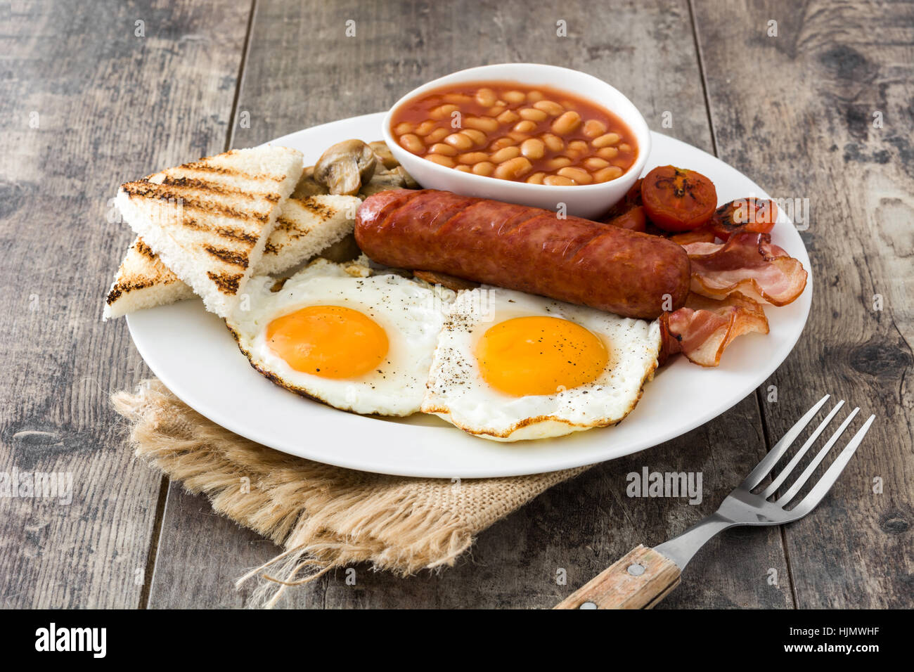Traditional full English breakfast with fried eggs, sausages, beans ...