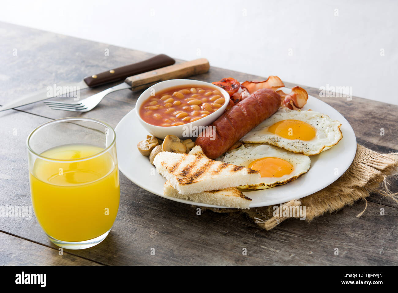 Traditional full English breakfast with fried eggs, sausages, beans ...