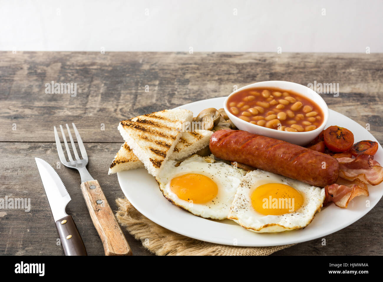 Traditional full English breakfast with fried eggs, sausages, beans ...