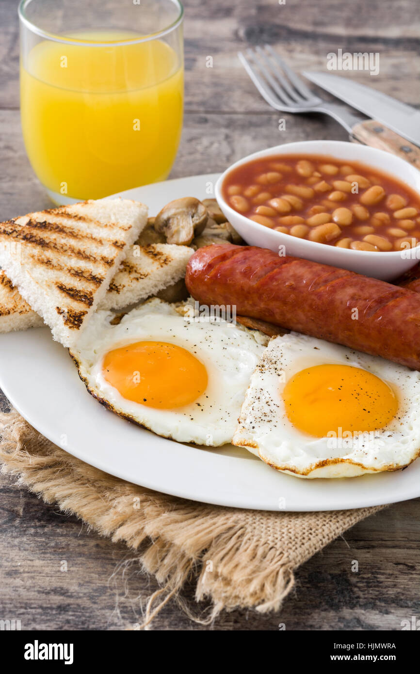 Traditional full English breakfast with fried eggs, sausages, beans ...