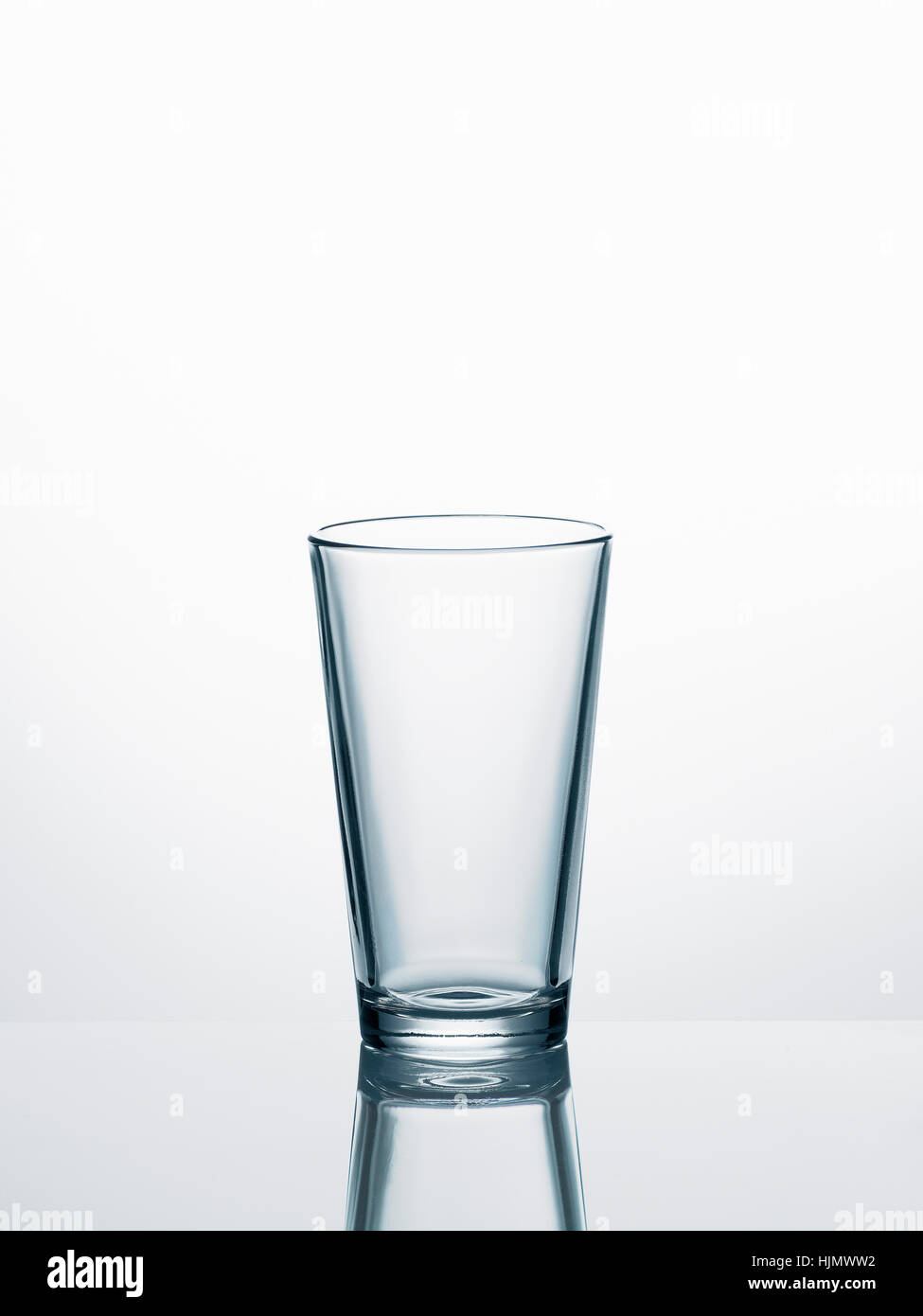 Empty water glass in front of white background Stock Photo - Alamy