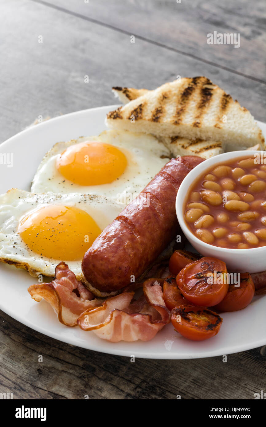 Traditional full English breakfast with fried eggs, sausages, beans ...