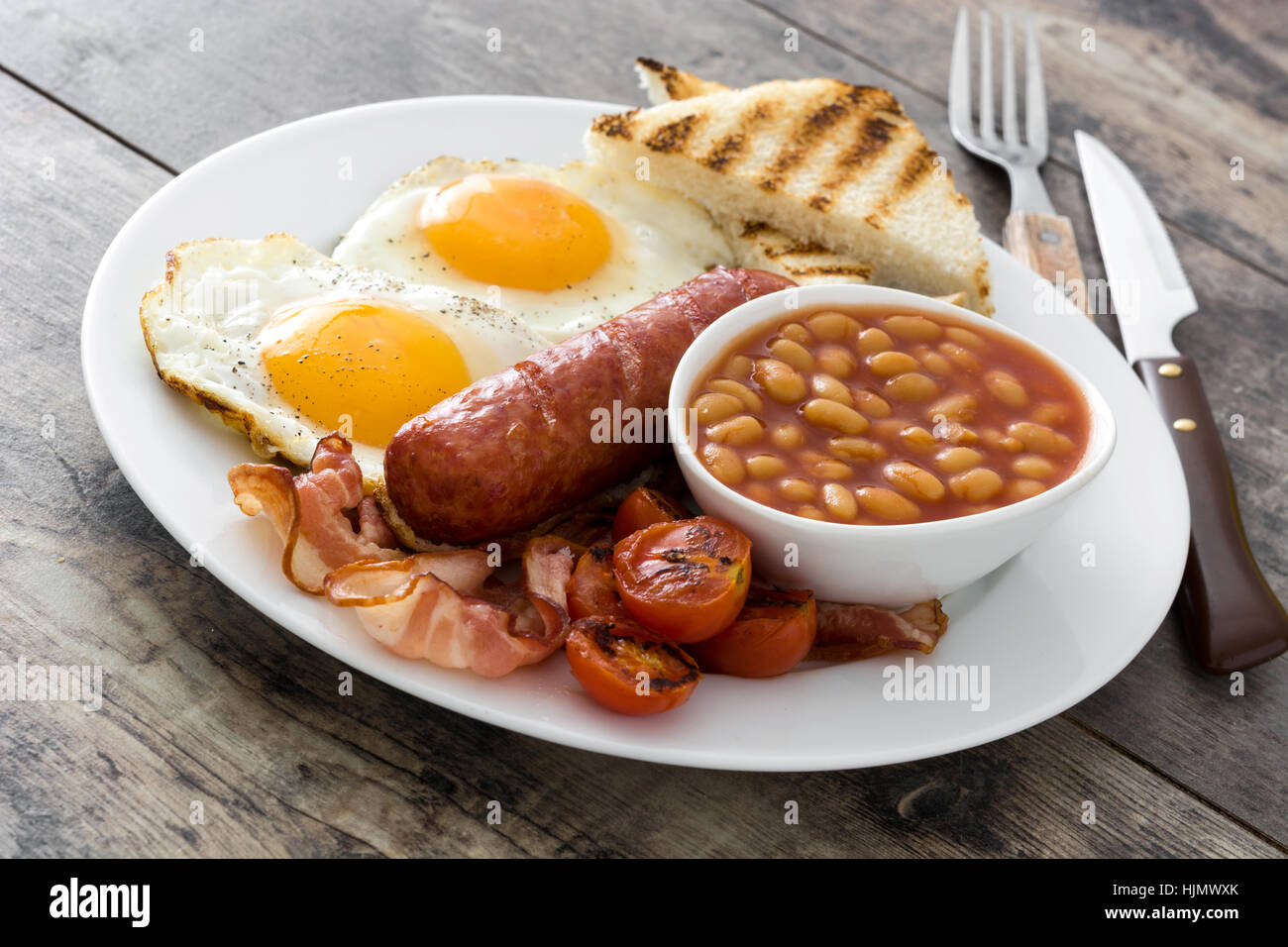 Traditional full English breakfast with fried eggs, sausages, beans ...