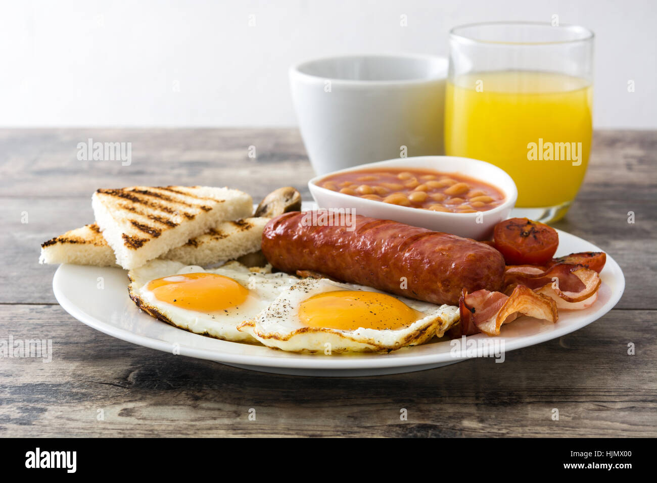 Traditional full English breakfast with fried eggs, sausages, beans ...