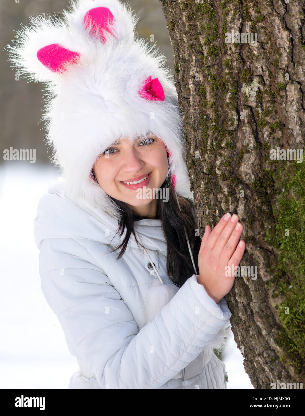 woman hiding behind tree in winter season Stock Photo - Alamy