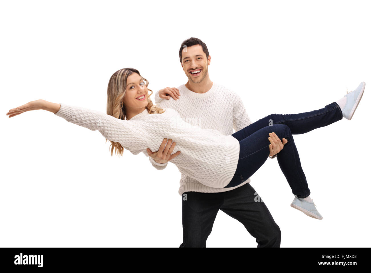Happy young man carrying a young woman in his arms isolated on white ...