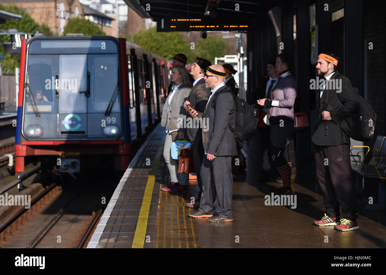 Competitors dressed in suits leave Mudchute DLR station in London after ...