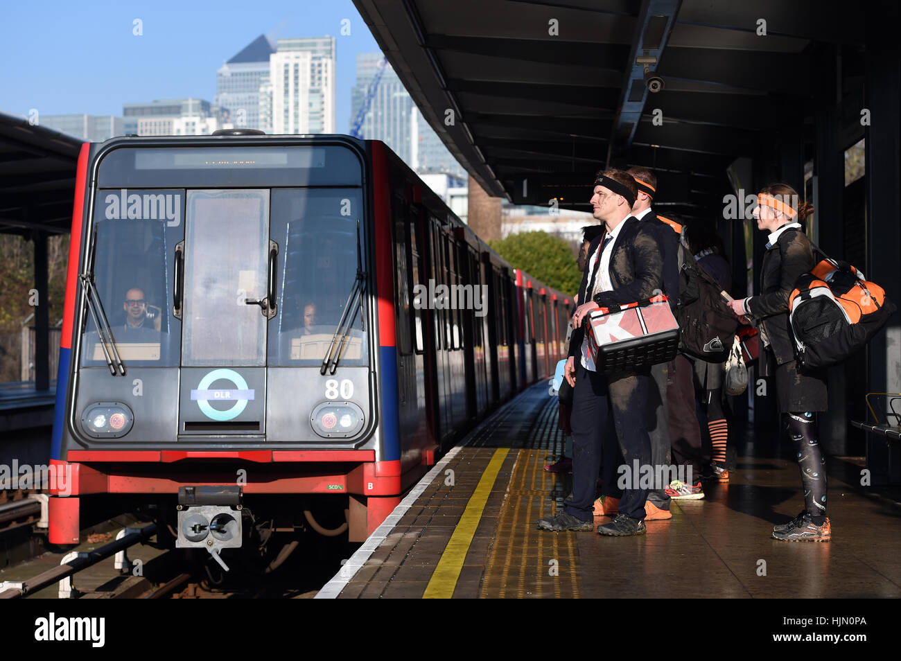 Competitors dressed in suits leave Mudchute DLR station in London after ...