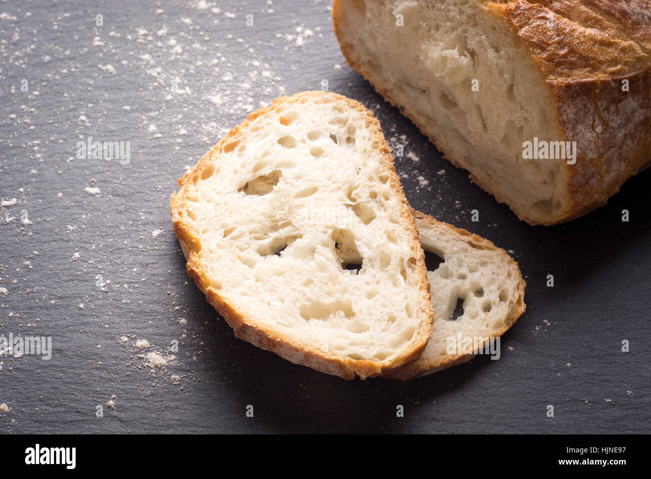 A loaf of wheat bread and slices on a slate plate Stock Photo - Alamy