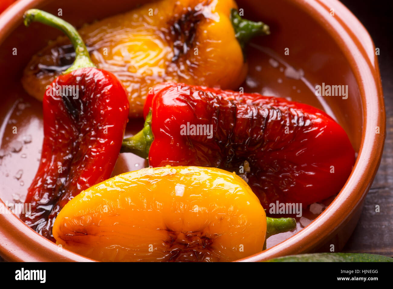Red and yellow grilled peppers with salt in brown bowl Stock Photo - Alamy