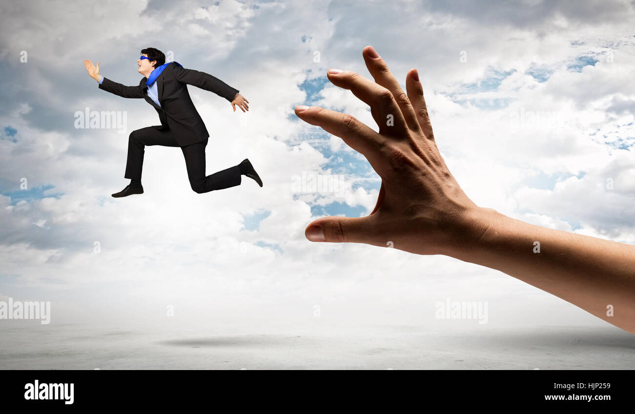 funny image of businessman trying to run away from hand Stock Photo - Alamy