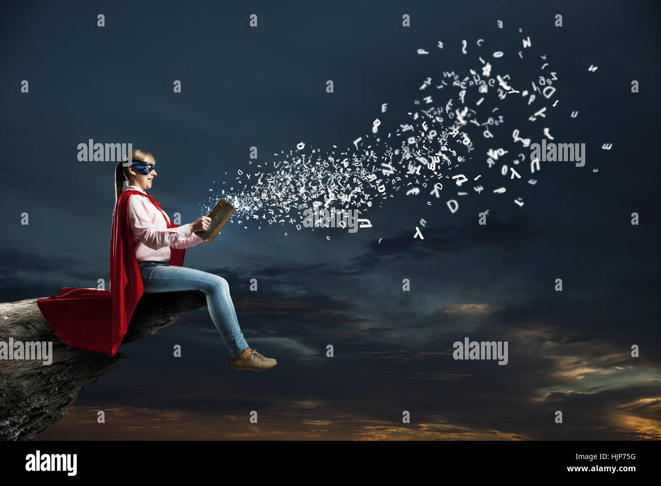 Young woman in super hero costume reading book hi-res stock photography ...