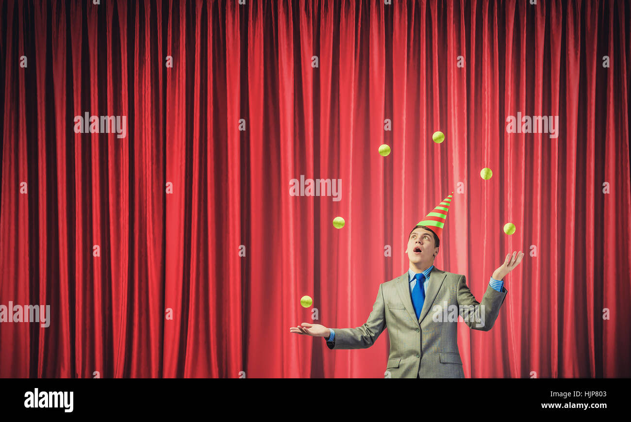 Young businessman in cap on stage juggling with balls Stock Photo - Alamy