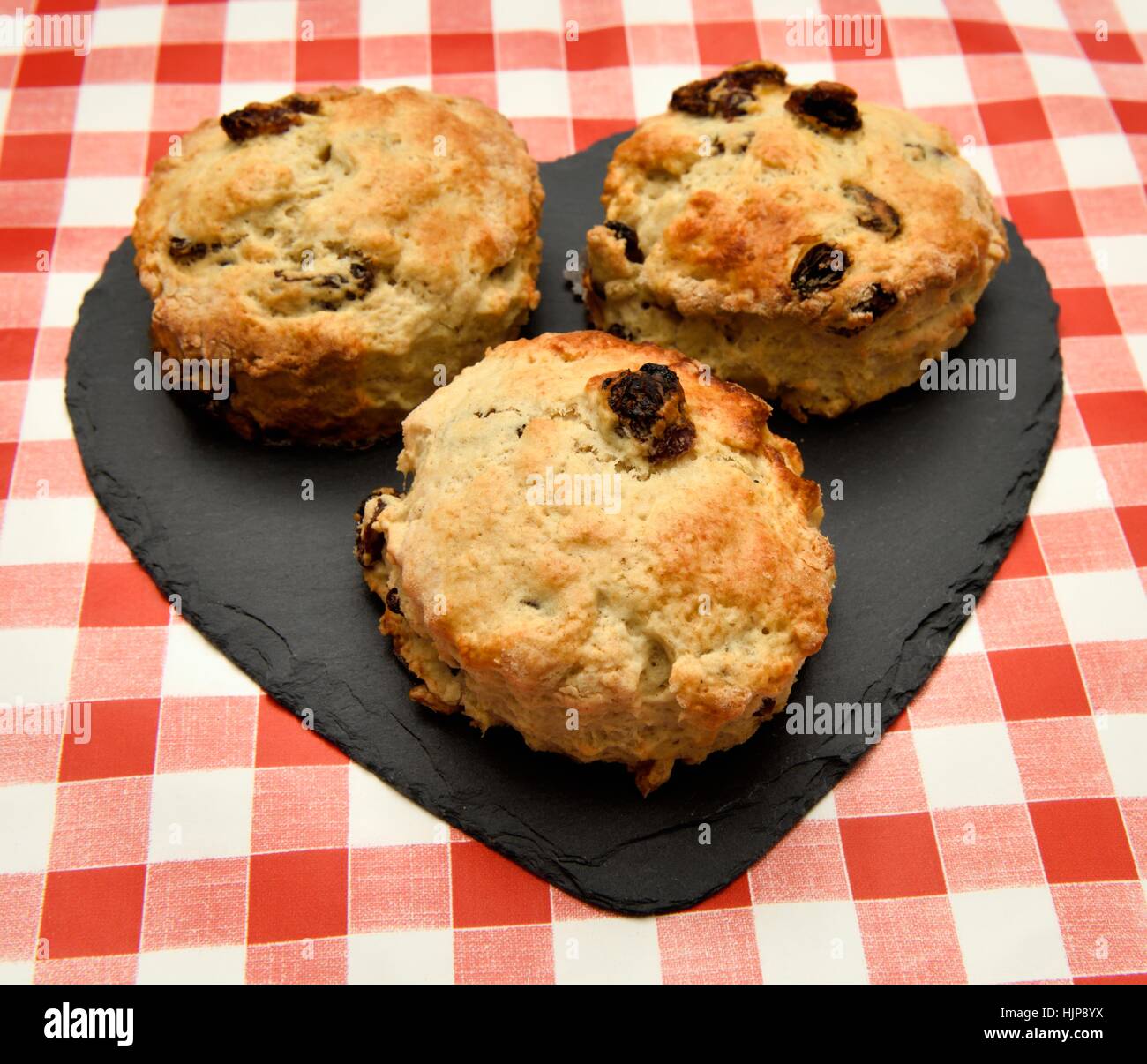 3 scones on a heart shaped piece of slate Stock Photo - Alamy